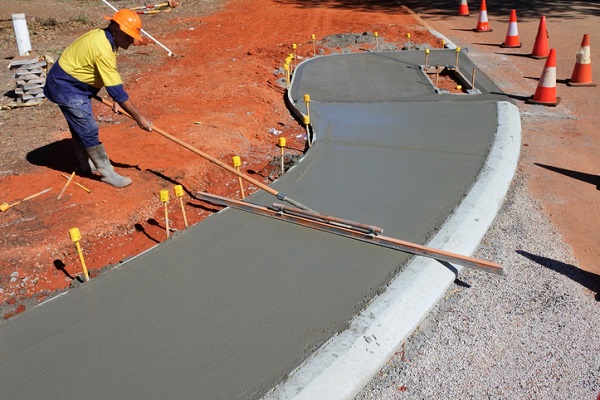 Aerial view of Australian road worker leveling a concrete sidewalk ...